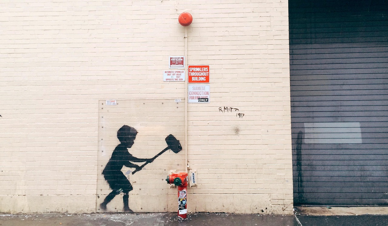Street art featuring a boy in Banksy style on a wall