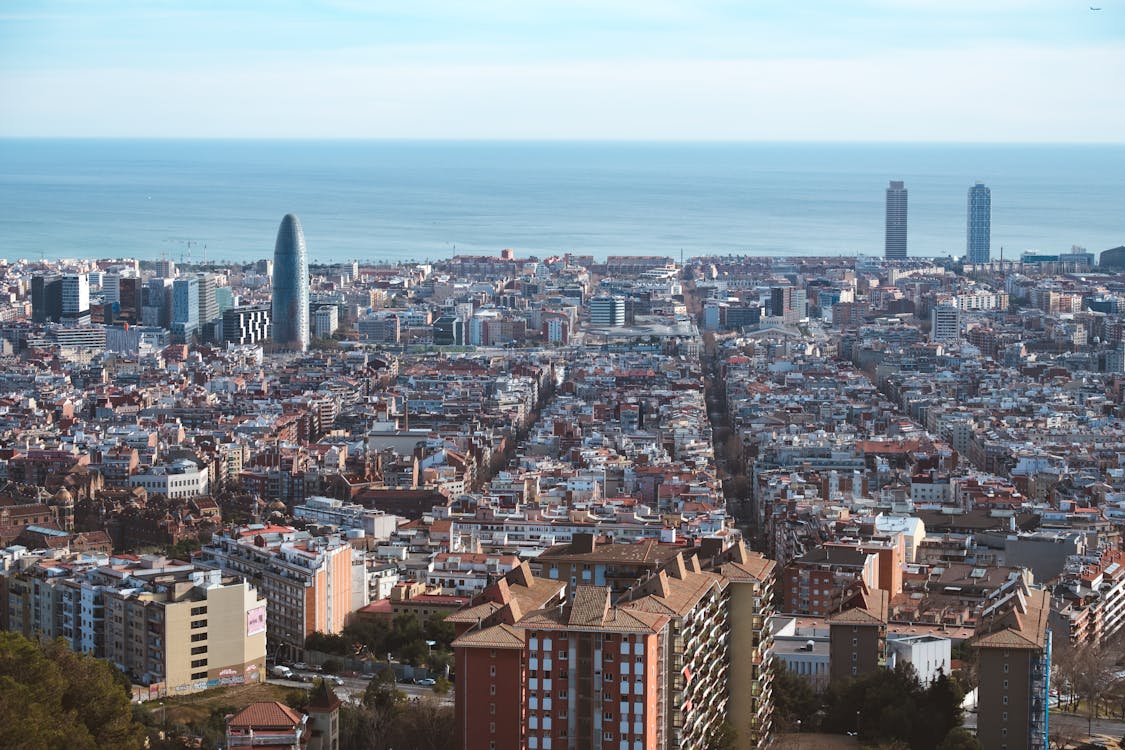 Panoramic aerial view of Barcelona showing city blocks and Mediterranean Sea