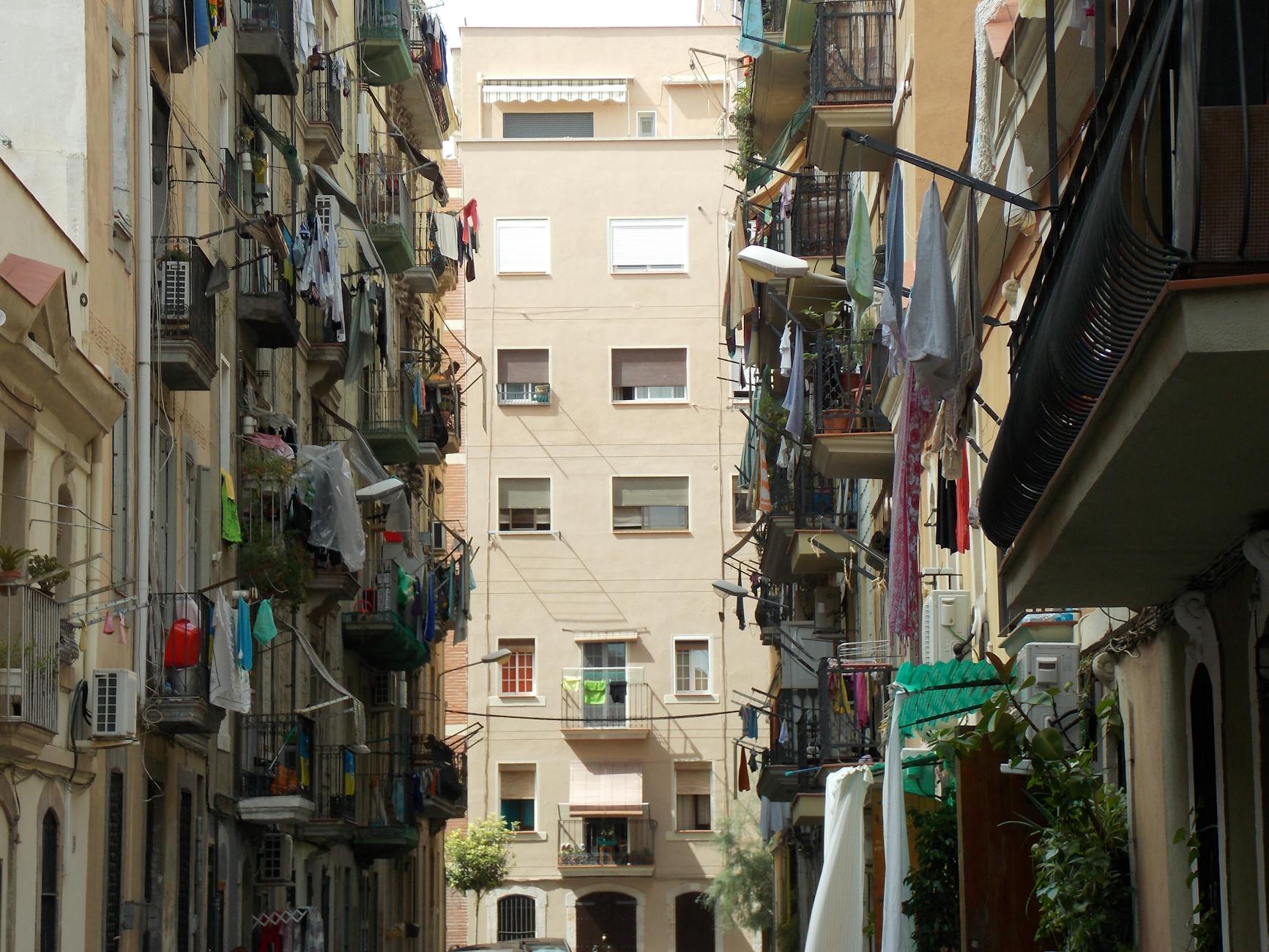 Narrow alley with apartment buildings and balconies in Barcelona Born district
