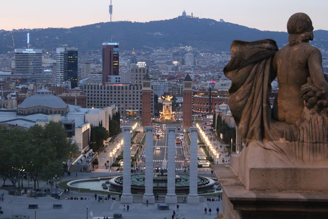 Barcelona urban landscape seen from Montjuic Hill at dusk with city lights