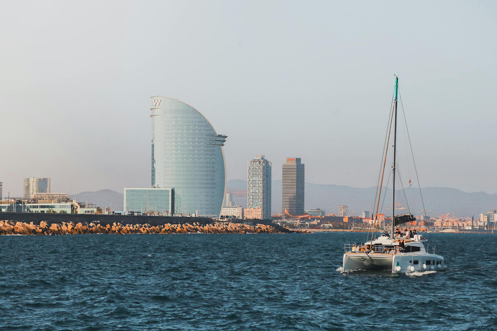 Barcelona coastal skyline with a sailing boat on the Mediterranean Sea