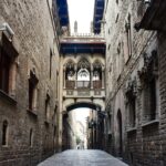 Narrow cobblestone street with medieval stone arches in Barcelona Gothic Quarter near Moco Museum