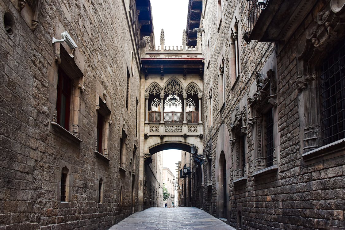 Narrow cobblestone street with stone archway in Barcelona Gothic Quarter