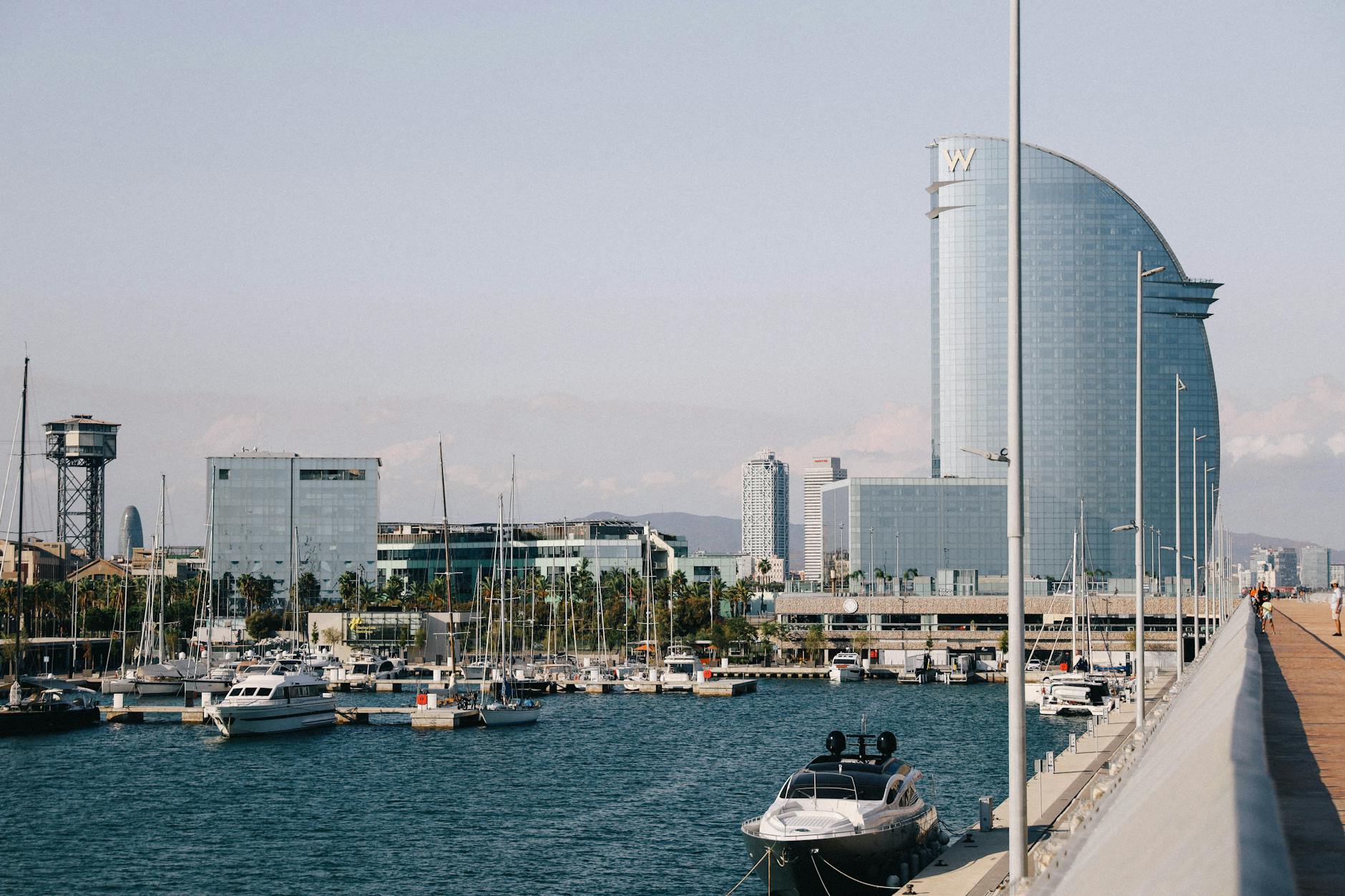 Modern architecture and boats in Barcelona scenic harbour with skyline