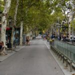 La Rambla boulevard in Barcelona with pedestrians walking past shops and historic buildings