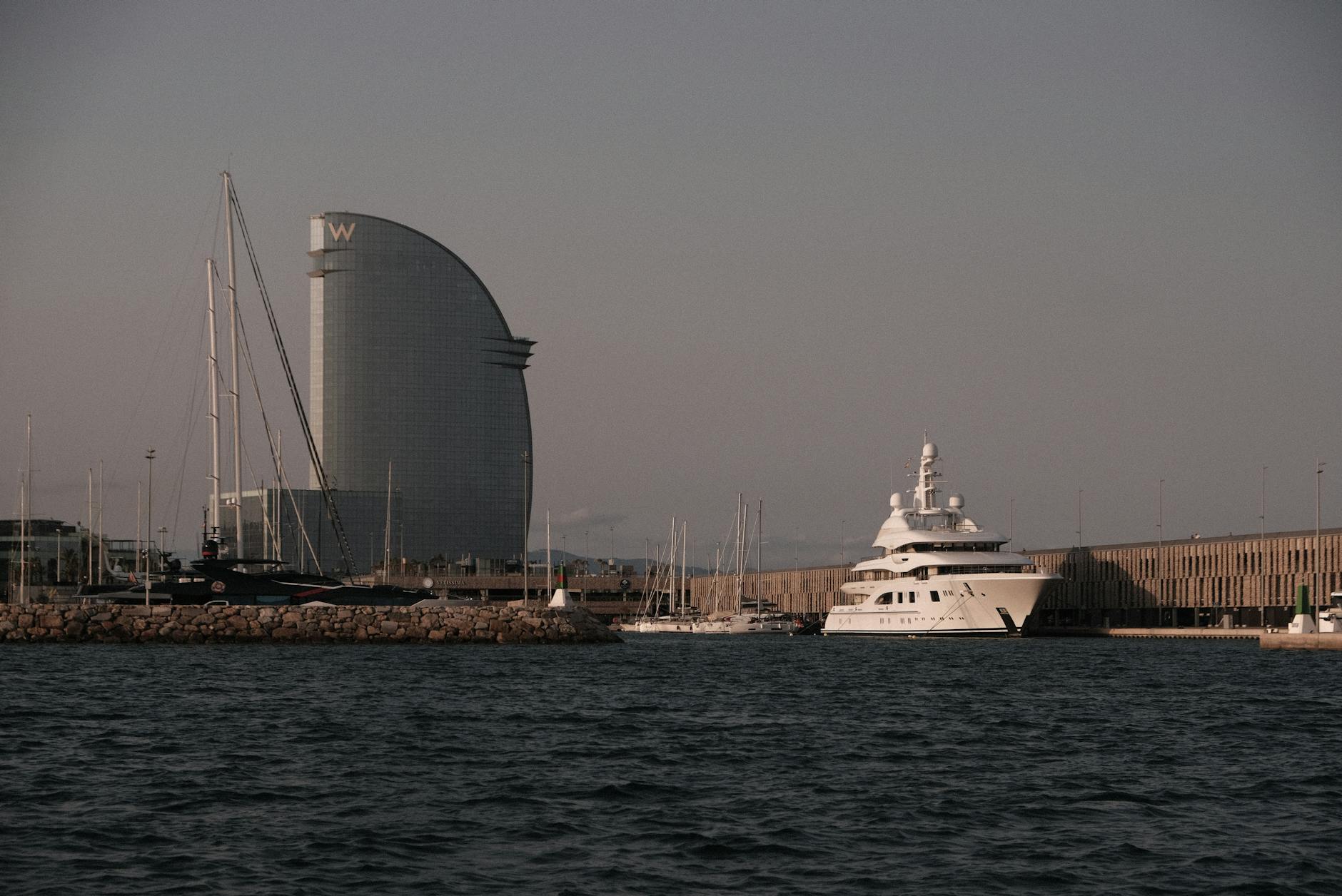 Port Vell in Barcelona at sunset with luxury yachts and the W Hotel