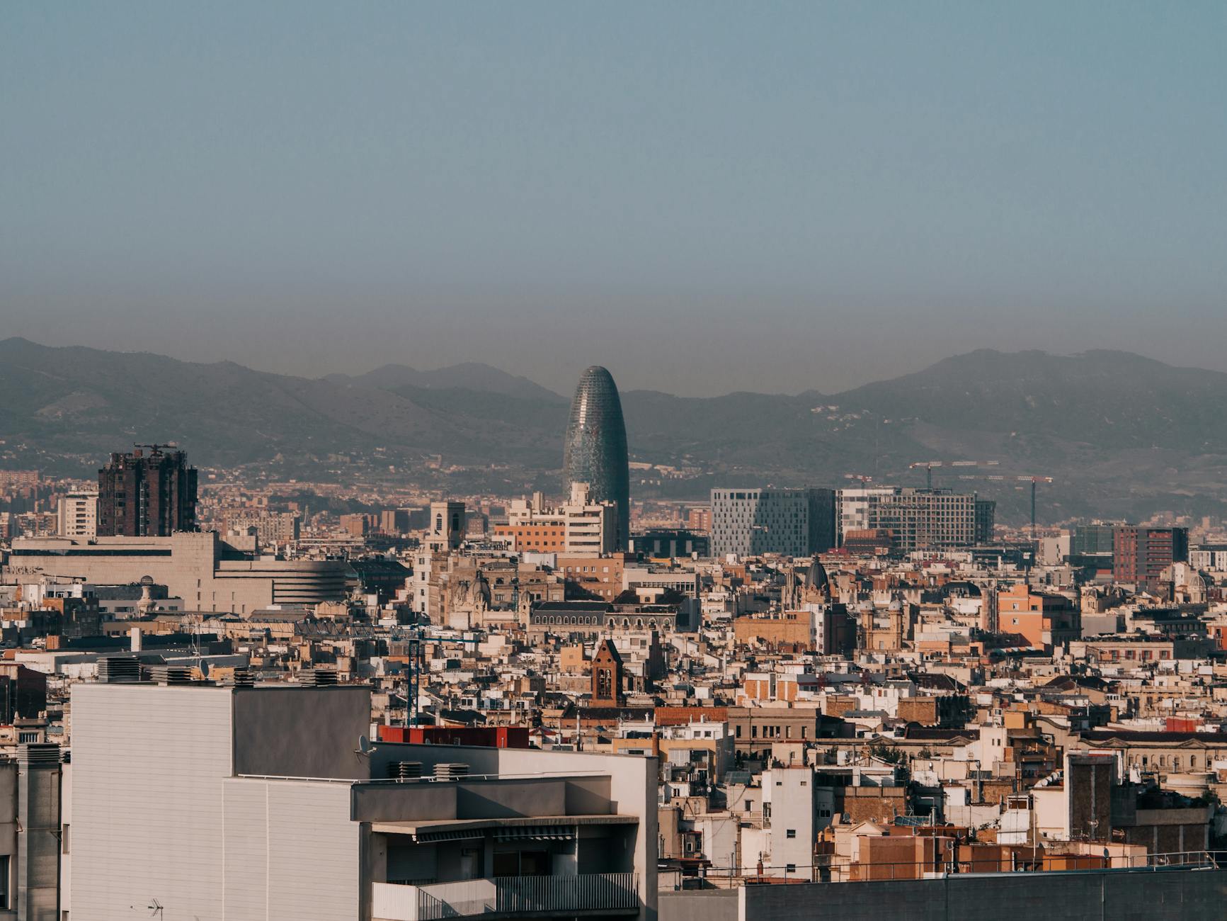 Panoramic view of Barcelona skyline with Torre Glories tower visible on a clear morning