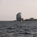 Barcelona coastline with sailing boats during a golden sunset cruise