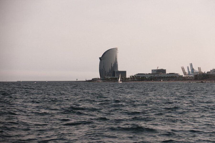 Barcelona coastline with sailing boats during a golden sunset cruise