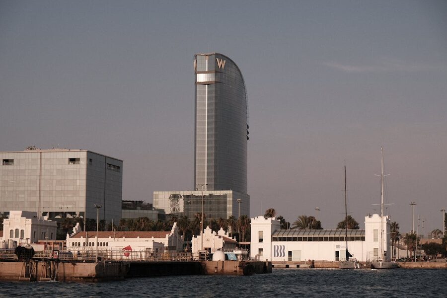 View of Barcelona iconic W Hotel and harbor at sunset with boats