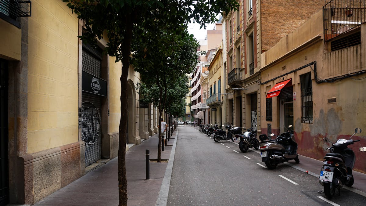 Narrow Barcelona street with parked motorbikes and classic architecture
