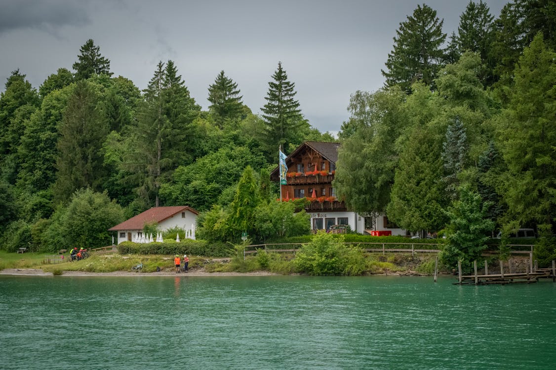 A lakefront cabin surrounded by green forest in the Bavarian Alps