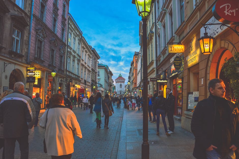 European street with historic buildings and evening shoppers under dusk sky