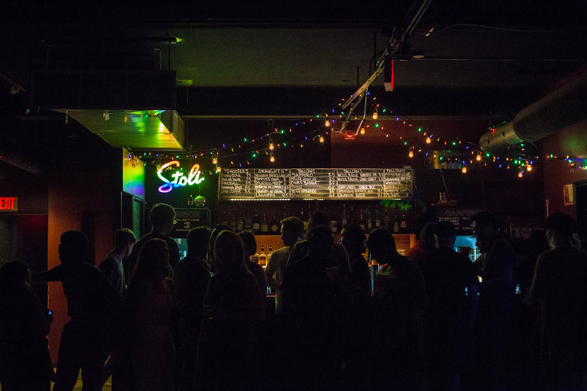 People enjoying nightlife at a bar with string lights