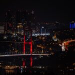 Istanbul Bosphorus Bridge lit up at night with city lights reflecting on the water