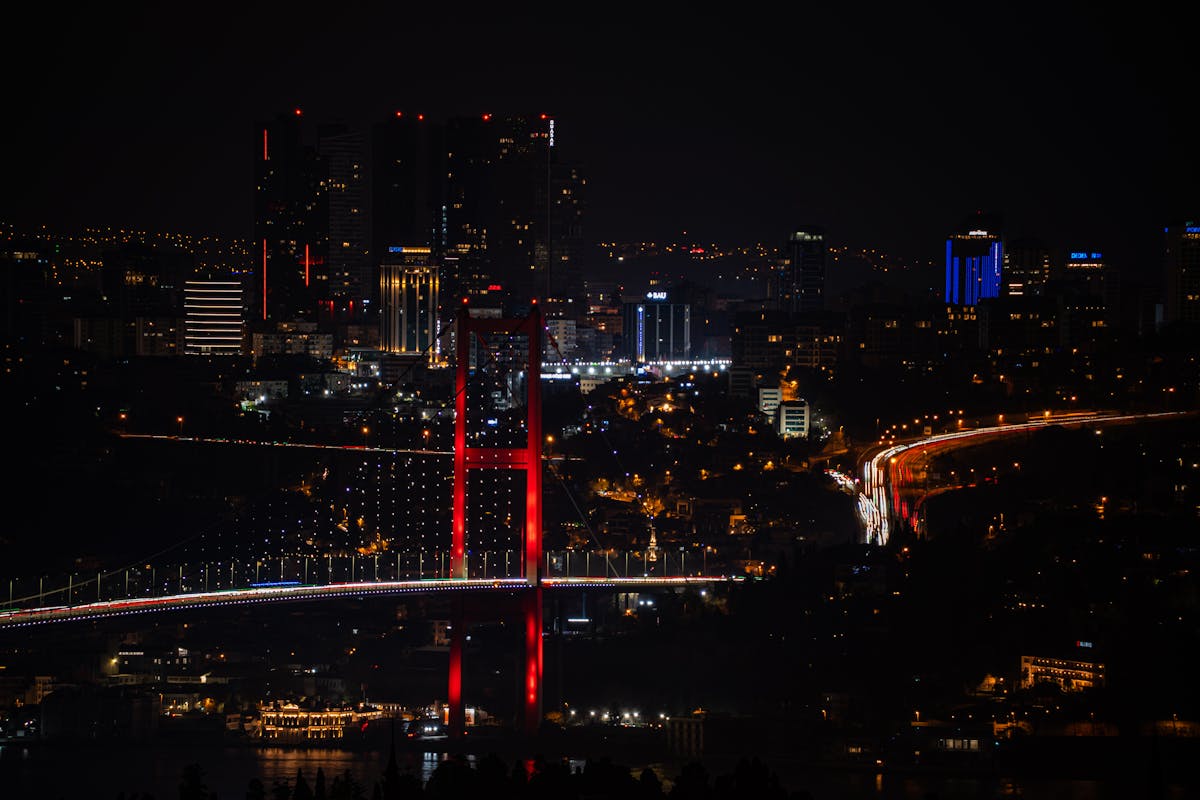Istanbul Bosphorus Bridge lit up at night with city lights reflecting on the water