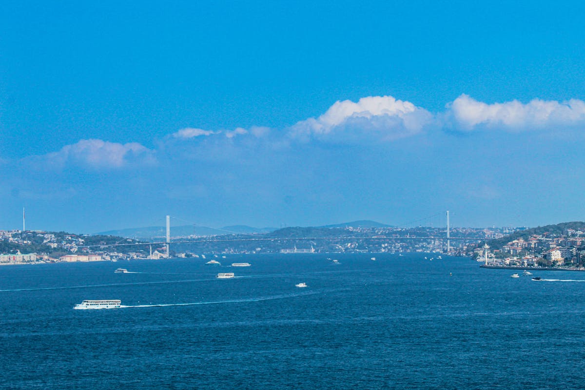 Bosphorus Strait with boats and bridges under clear blue sky in Istanbul