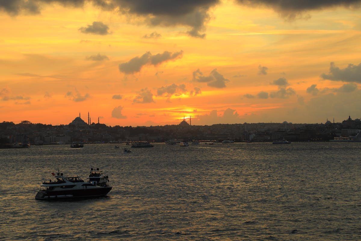 Golden sunset over the Bosphorus strait with boats and Istanbul skyline