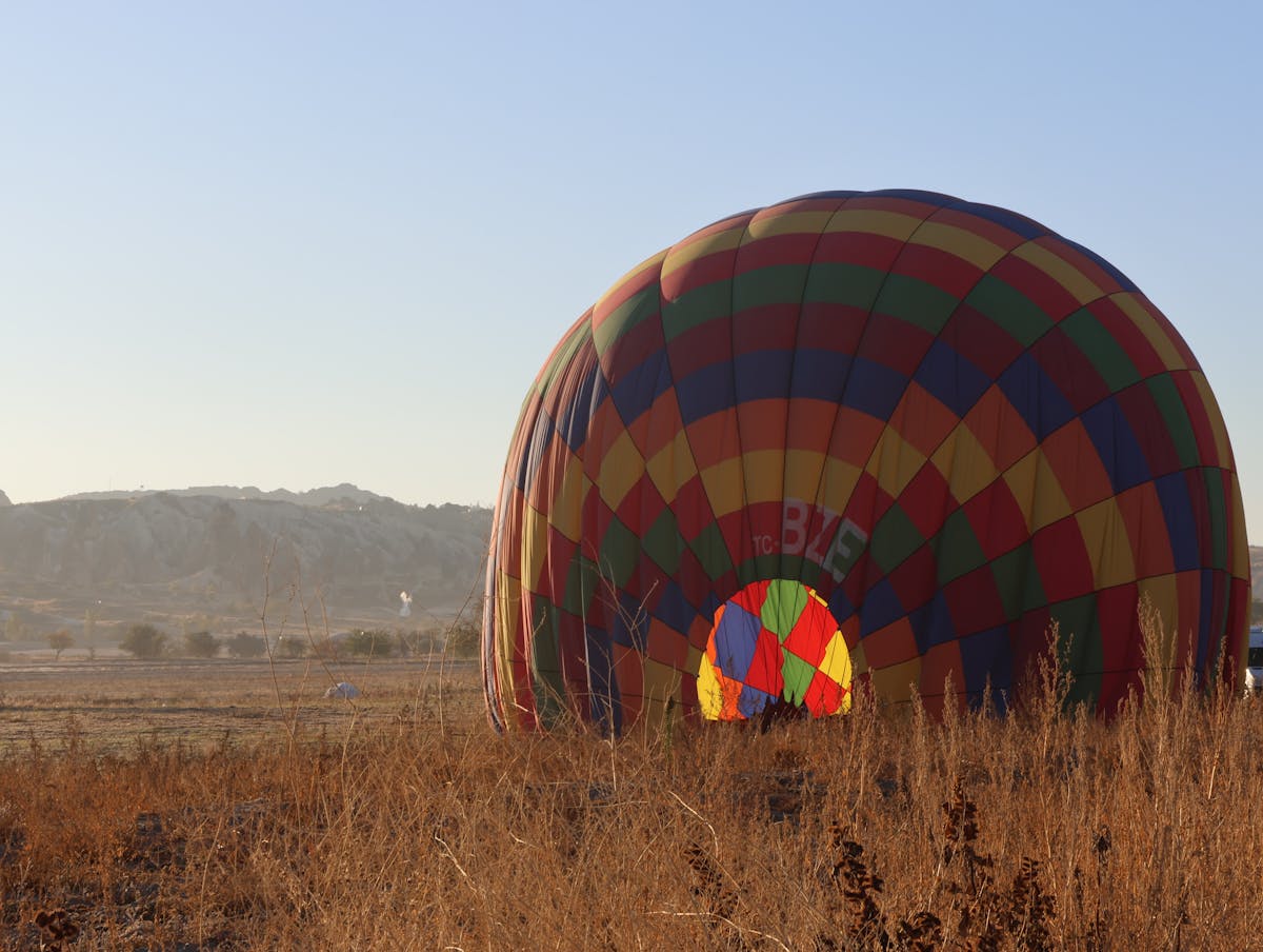 Deflated hot air balloon being prepared for flight in Cappadocia landscape