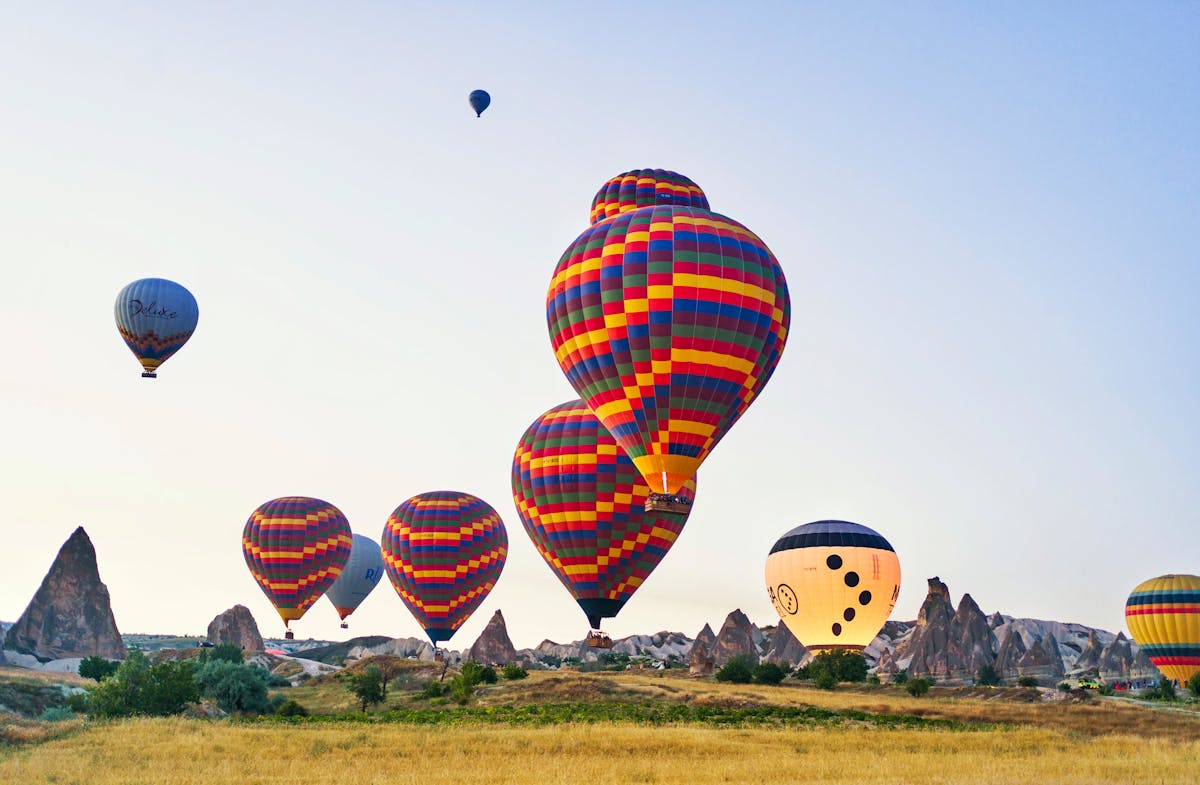 Colourful hot air balloons soaring above Cappadocia unique landscape in Turkey