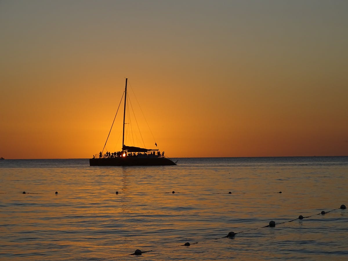 Silhouette of a sailing boat on the sea during sunset