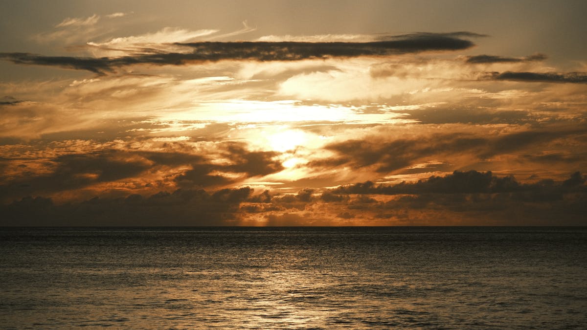 Dramatic golden sunset over the ocean with clouds