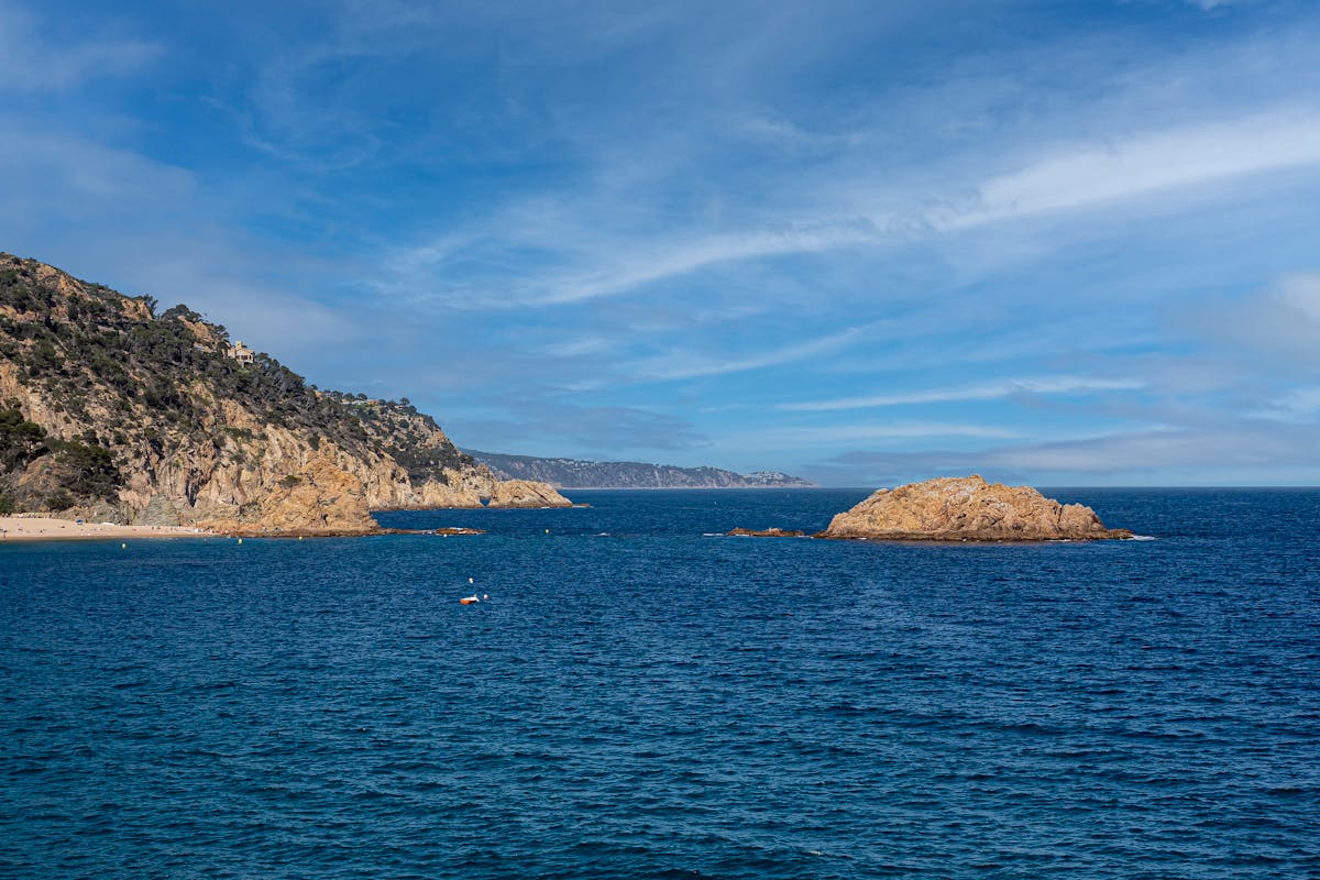 View of a rocky coastline and blue water under blue sky