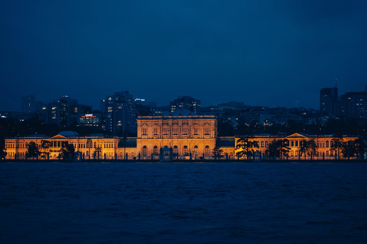 Dolmabahce Palace illuminated at night on the Bosphorus coast in Istanbul