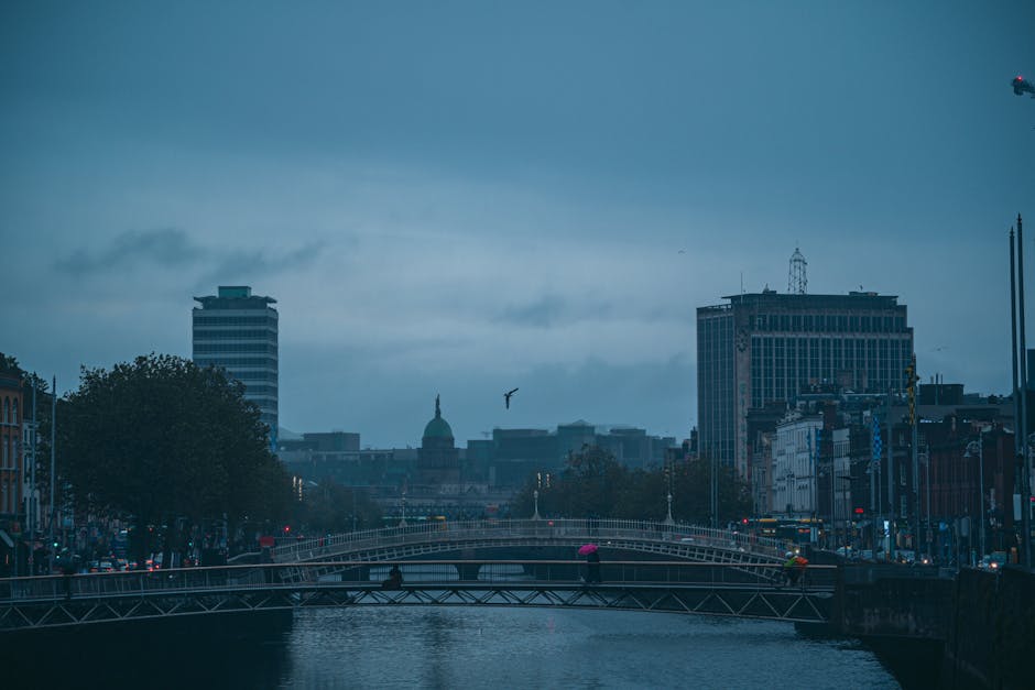 Moody Dublin cityscape showcasing Ha'penny Bridge at dusk with overcast sky