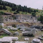 Panoramic view of ancient Ephesus ruins with green hills in the background