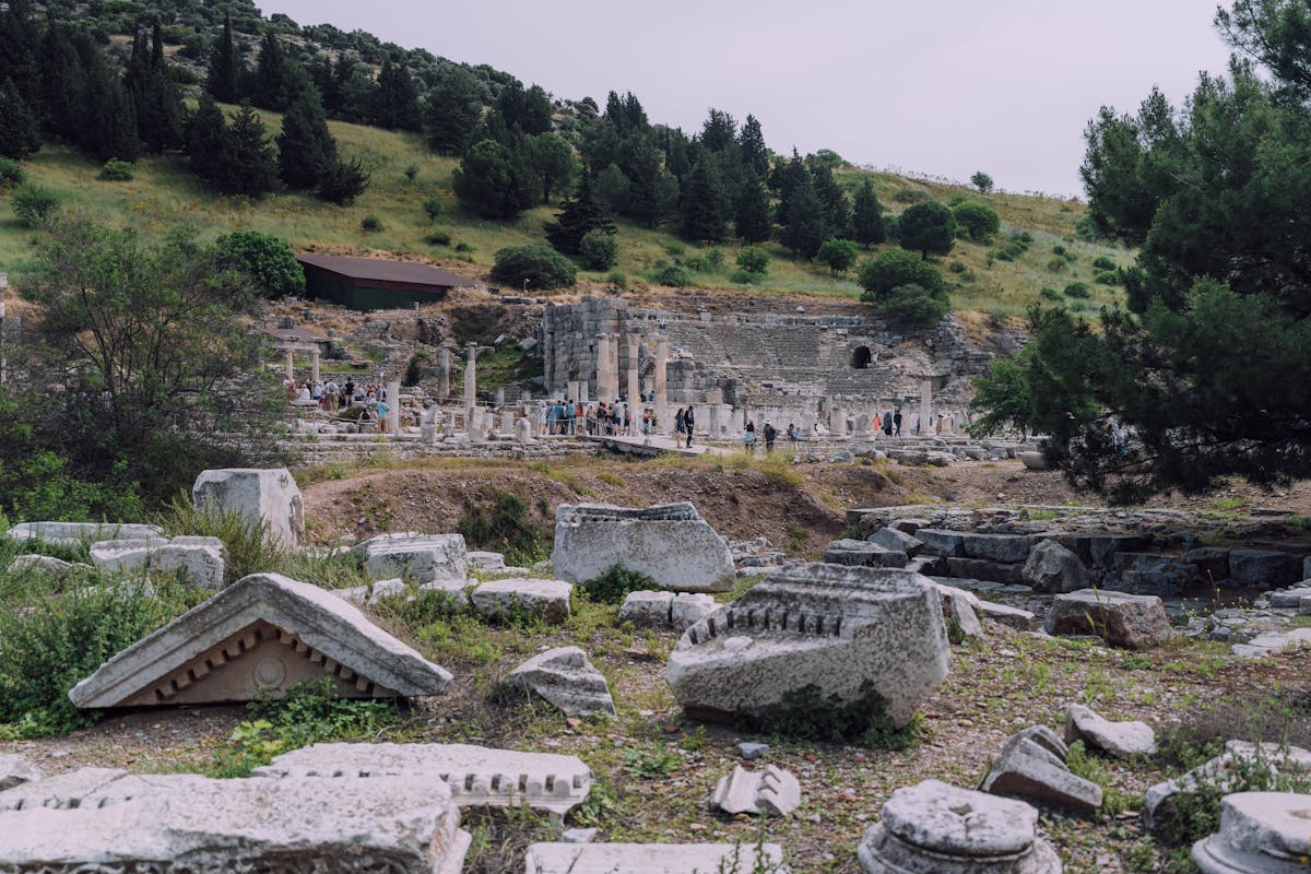Panoramic view of ancient Ephesus ruins with green hills in the background