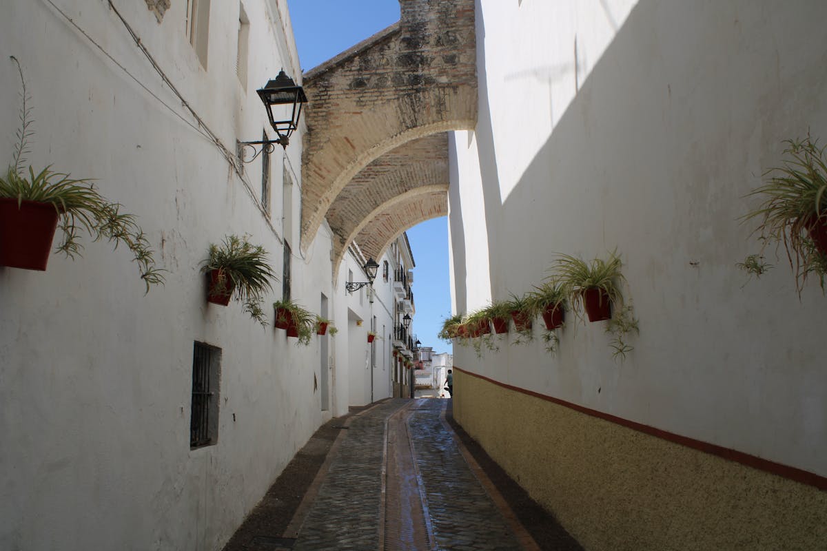 An alley in a Spanish city with narrow white walls
