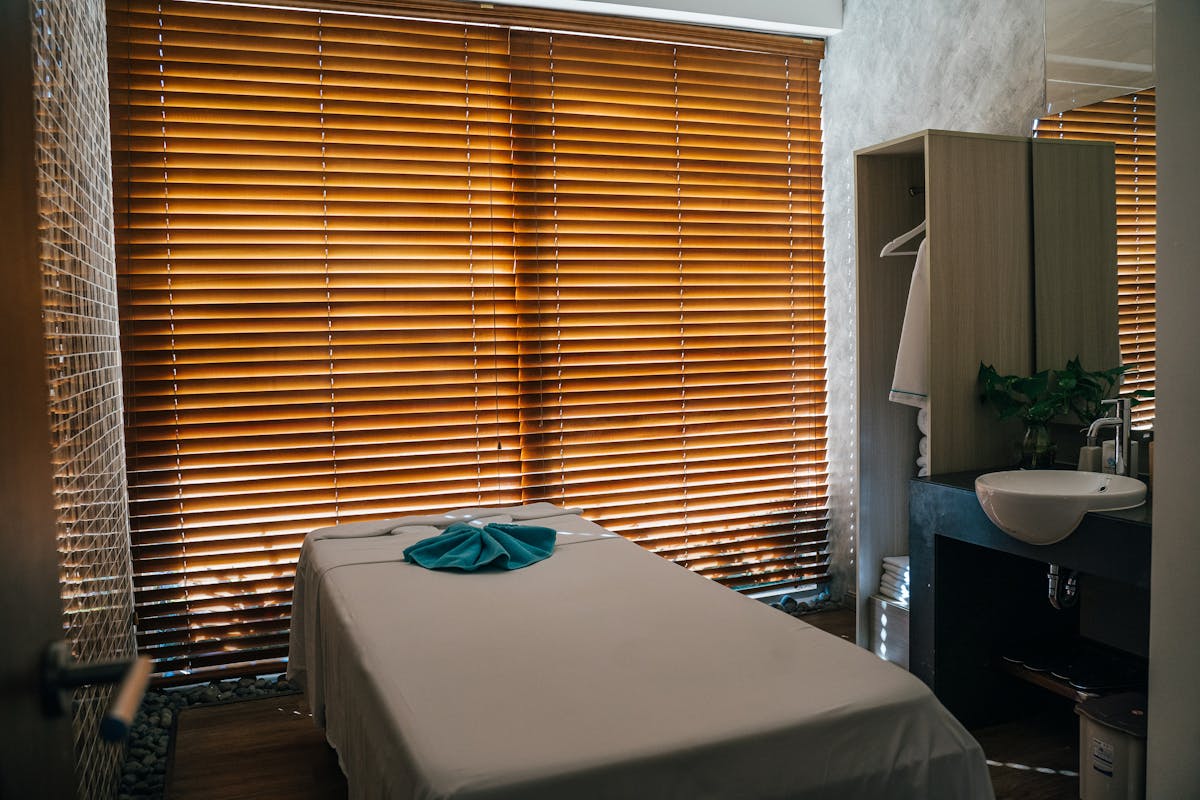 A massage table near window blinds in spa