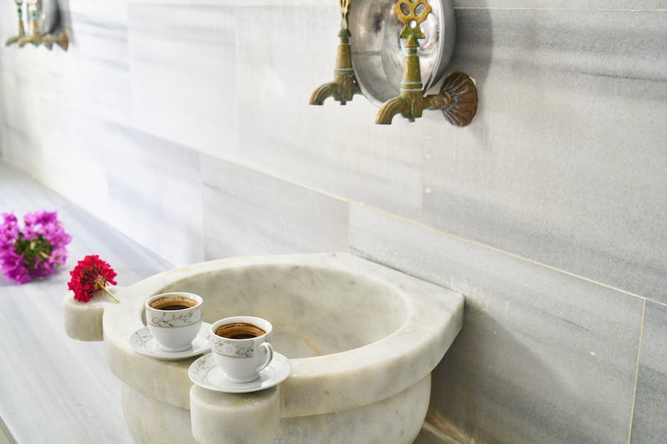 Turkish coffee cups on a marble sink with ornate faucets
