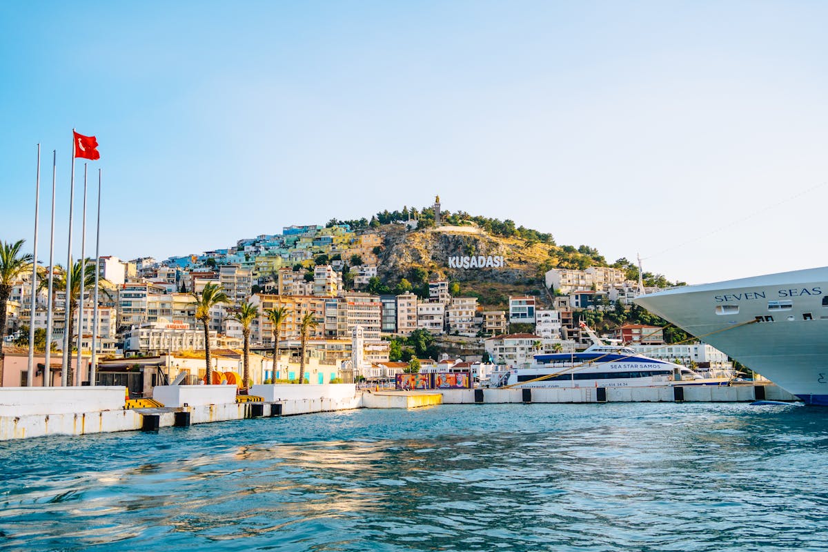 Scenic view of Kusadasi port with cruise ships and hillside lettering
