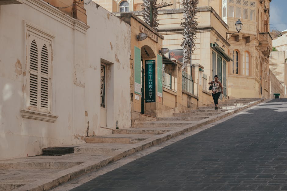 A woman walking along a picturesque street in Victoria Gozo Malta