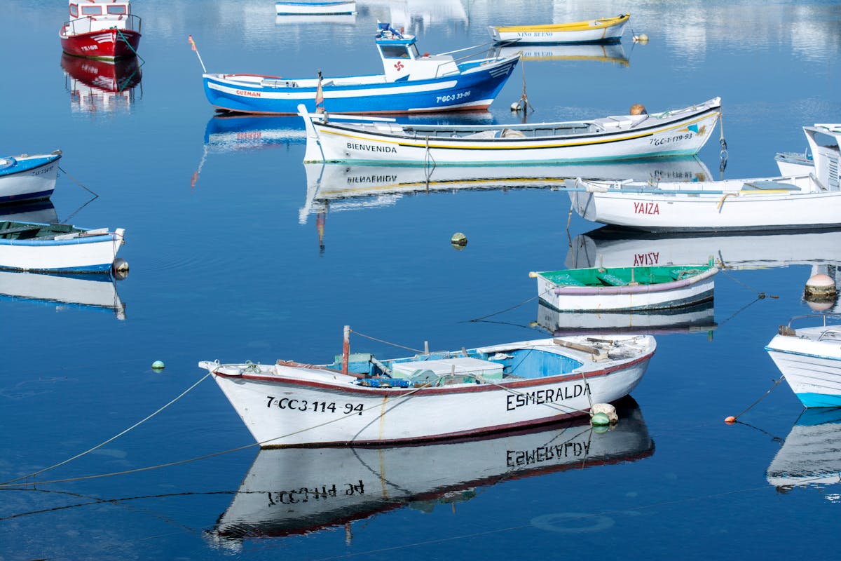 Colorful boats anchored in a calm harbor in the Canary Islands, Spain