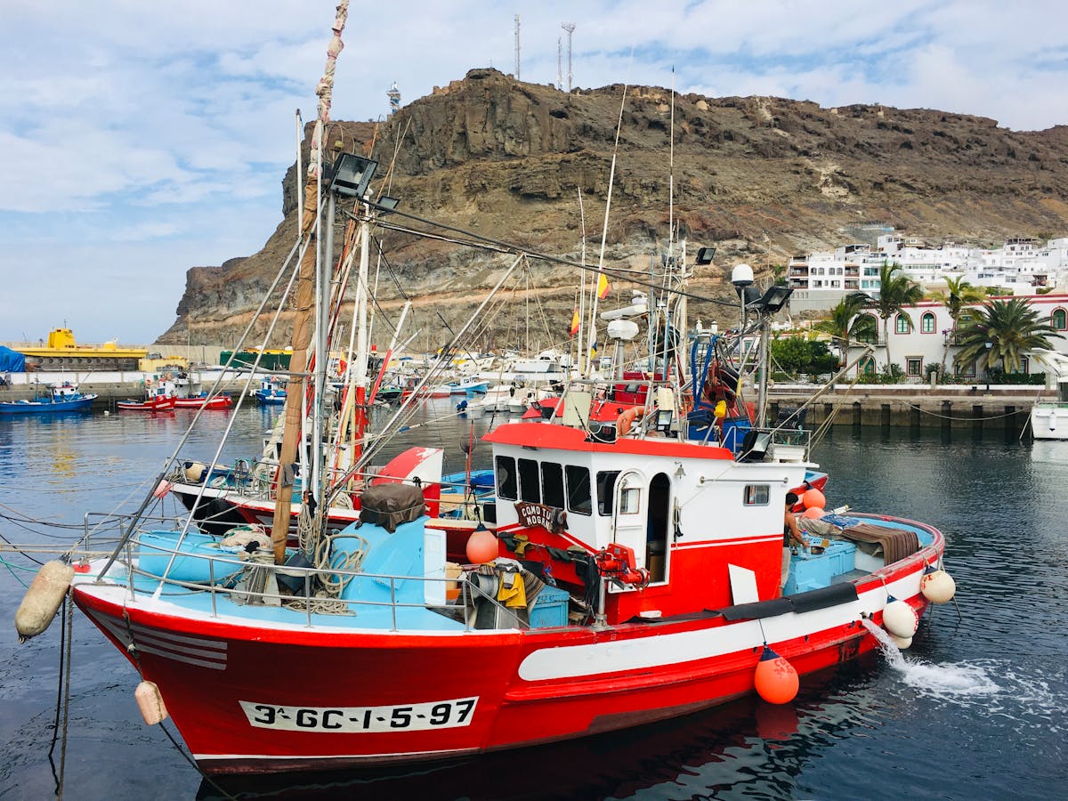 Red fishing boat docked at the harbor in Puerto de Mogan, Gran Canaria