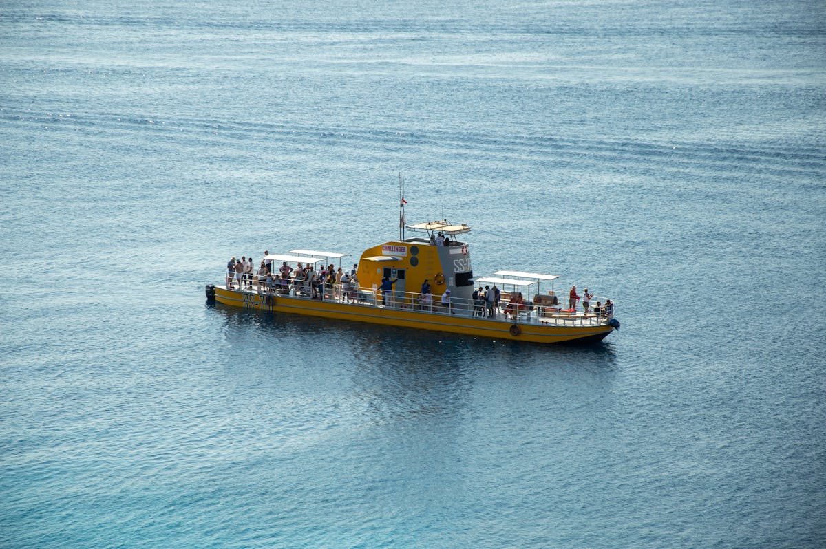 A bright yellow tourist submarine boat carrying passengers on the ocean