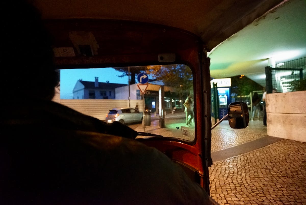 View from inside a tuk tuk driving through city streets