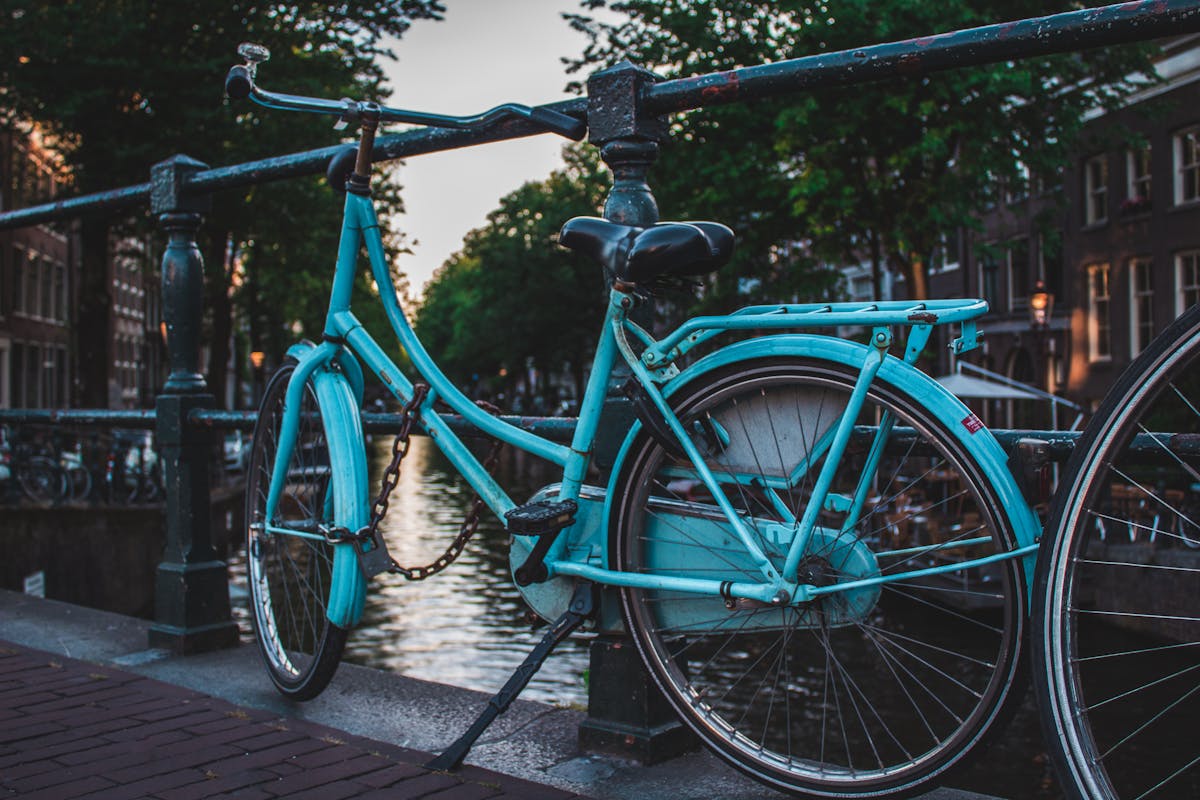 Classic blue bicycle parked on a canal bridge in Amsterdam