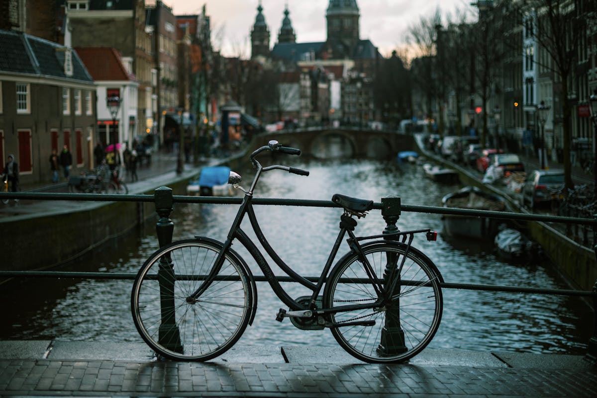 Classic bicycle parked on a bridge over Amsterdam canals