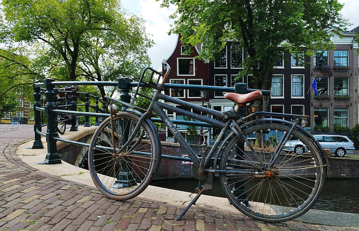 Rustic bicycle on a canal bridge in Amsterdam