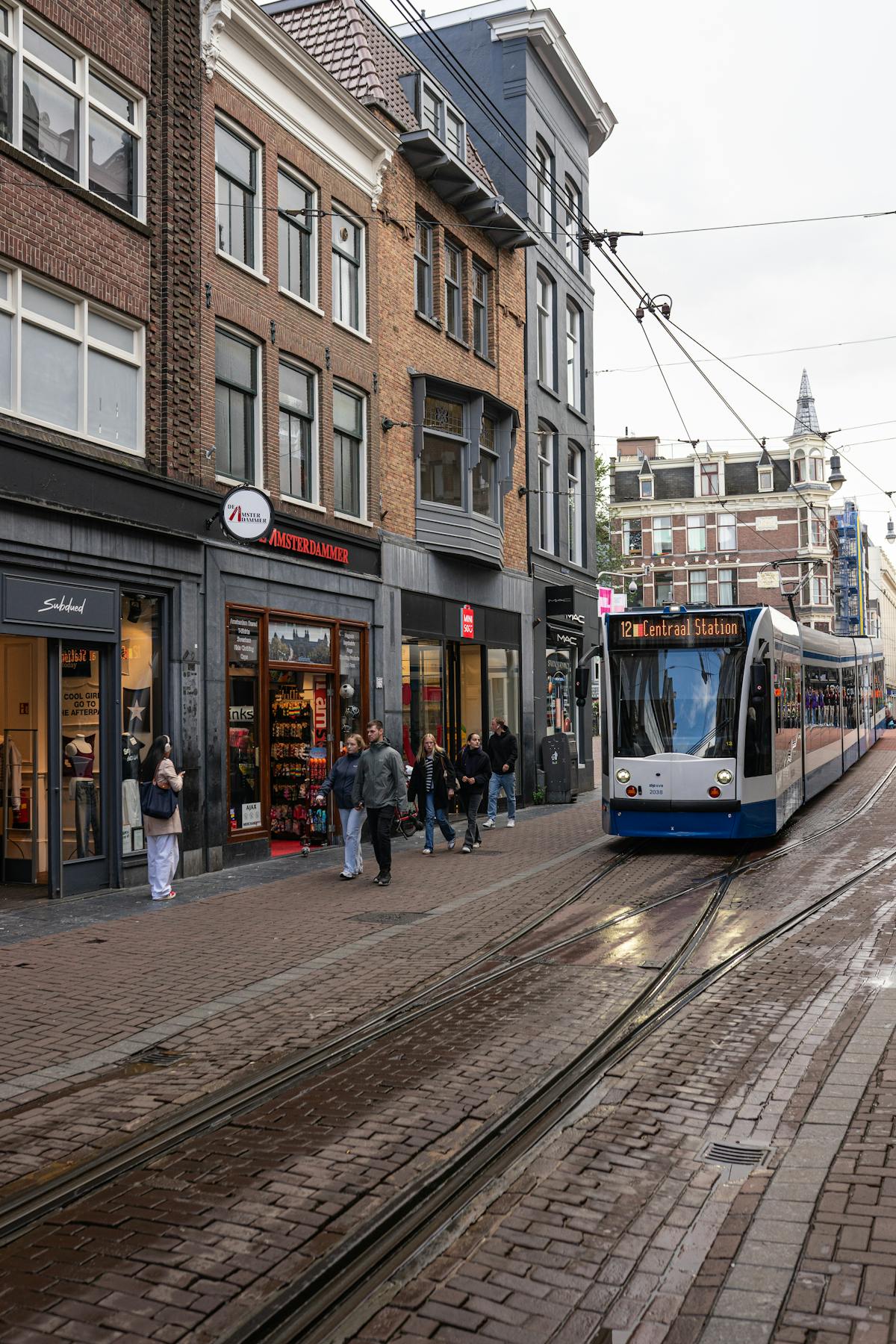 Tram passing through a busy Amsterdam street surrounded by historic buildings