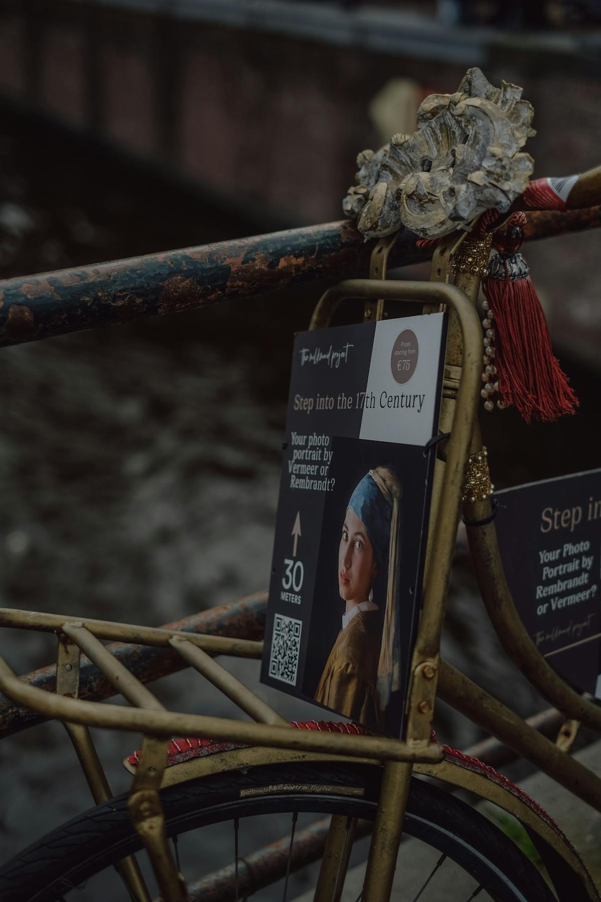 A rustic bicycle displays a 17th-century art poster blending vintage and modern Dutch culture