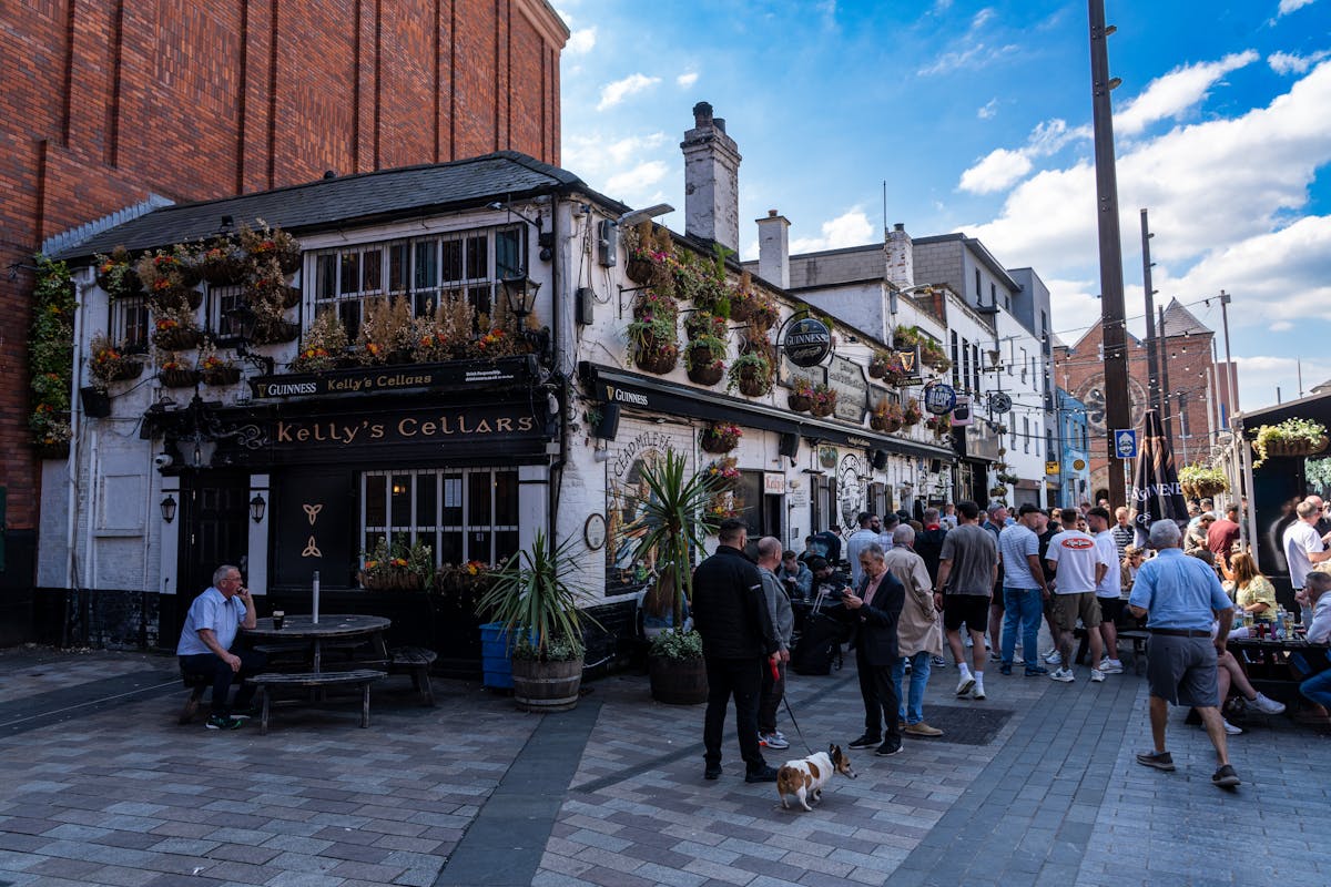Crowds gathering outside Kellys Cellars in Belfast on a sunny day