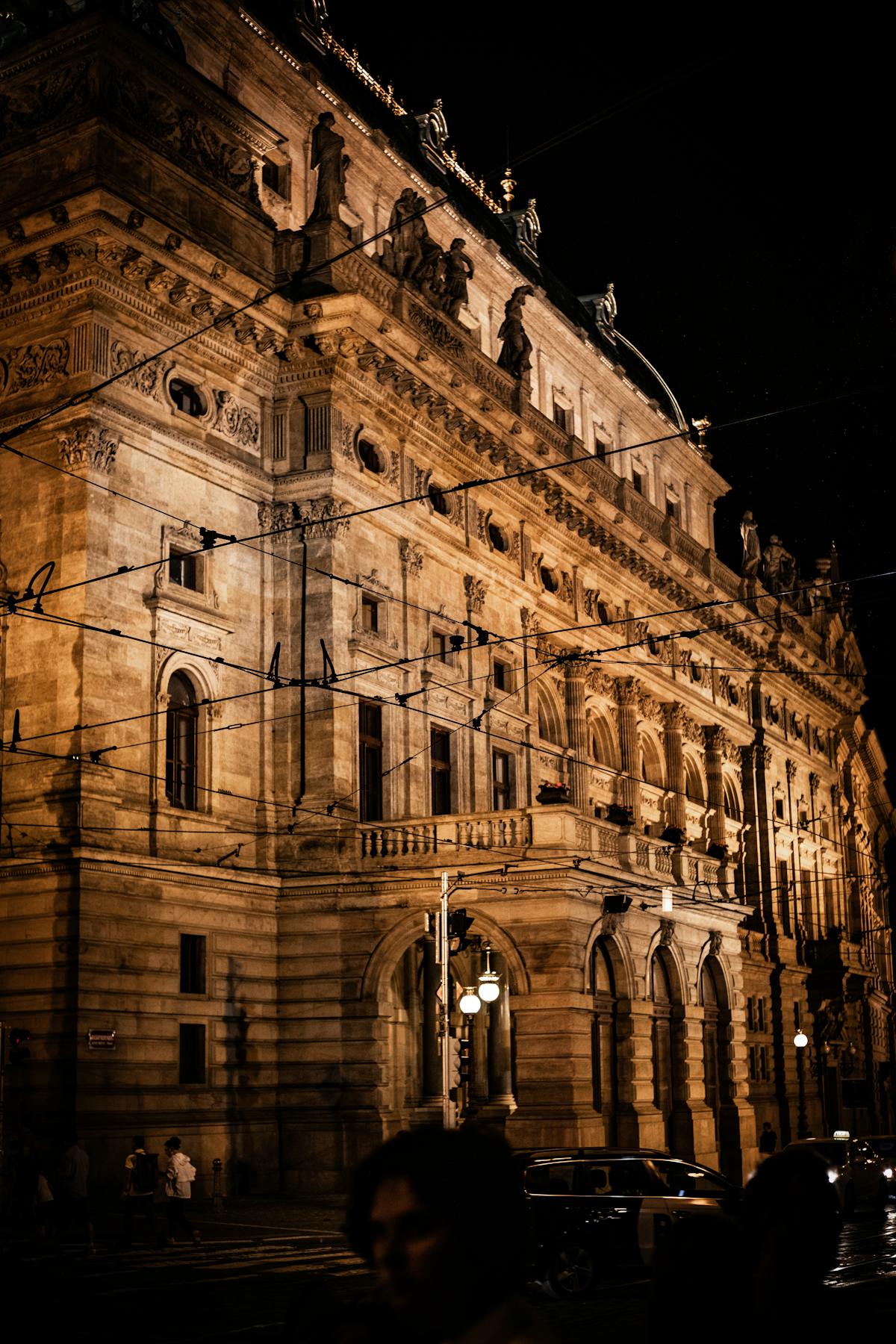 Prague National Theatre facade illuminated at night with golden lighting