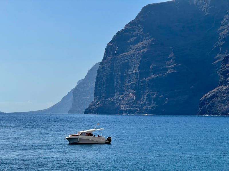 A boat cruising near the stunning cliffs of Los Gigantes, Tenerife
