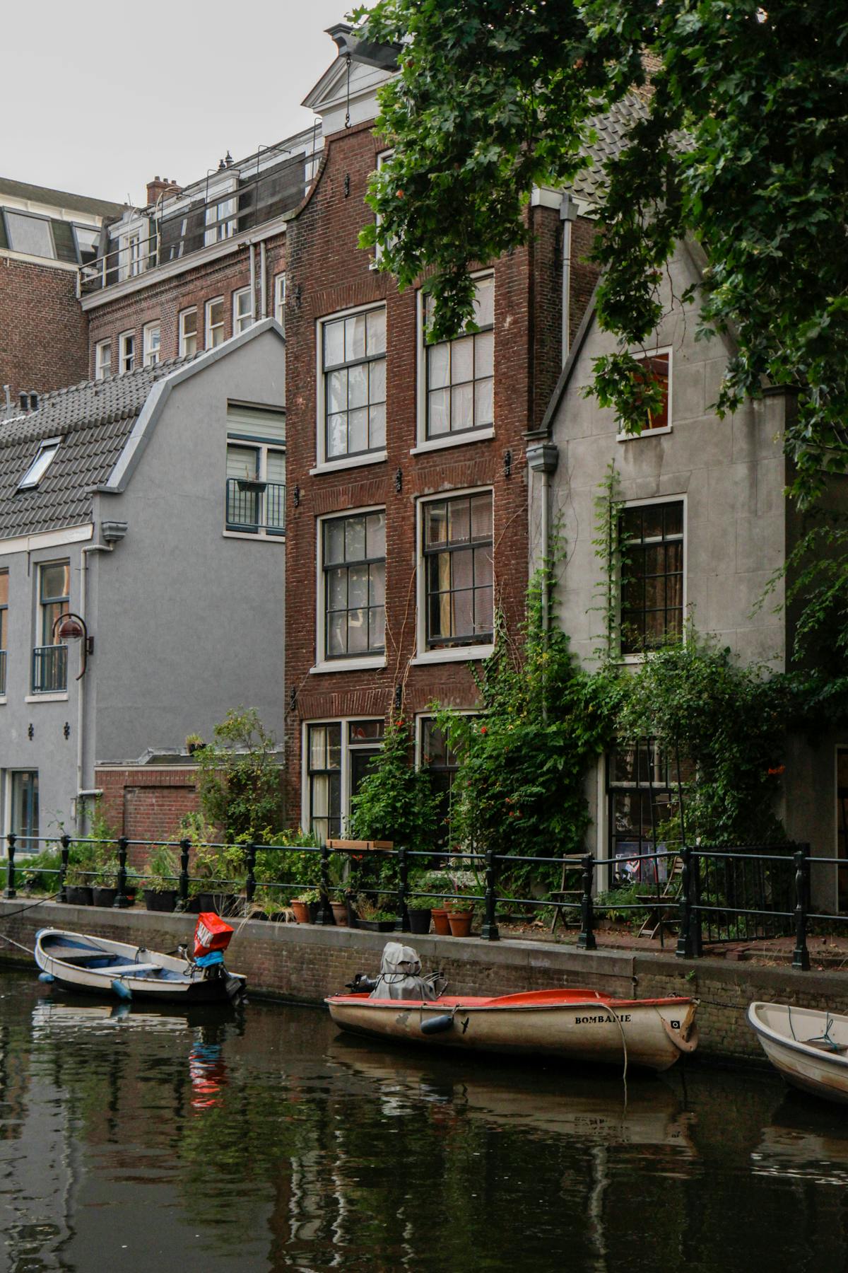 Picturesque canal houses in Amsterdam with boats docked along the waterway