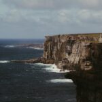 Cliffs of Moher rising from the Atlantic Ocean with waves crashing below